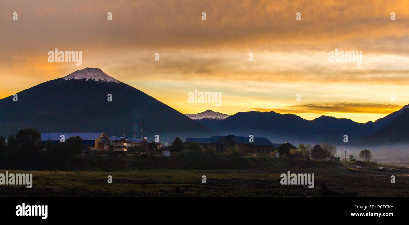 Hornopiren city skyline with sunset and vulcan hornopiren with snowy ...