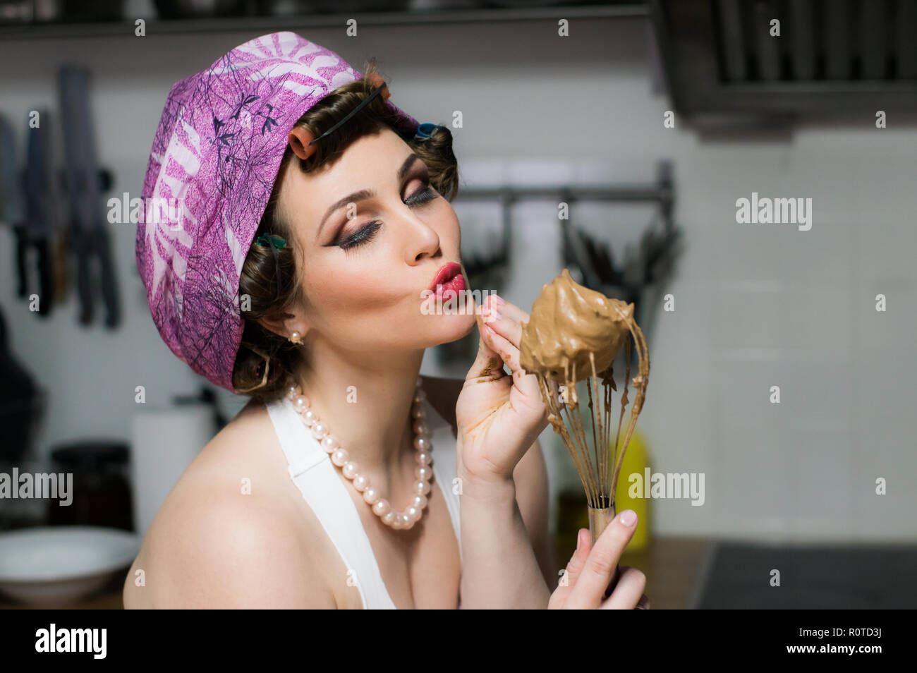 Beautiful girl cooks on kitchen, chocolate cream on corolla, near the ...