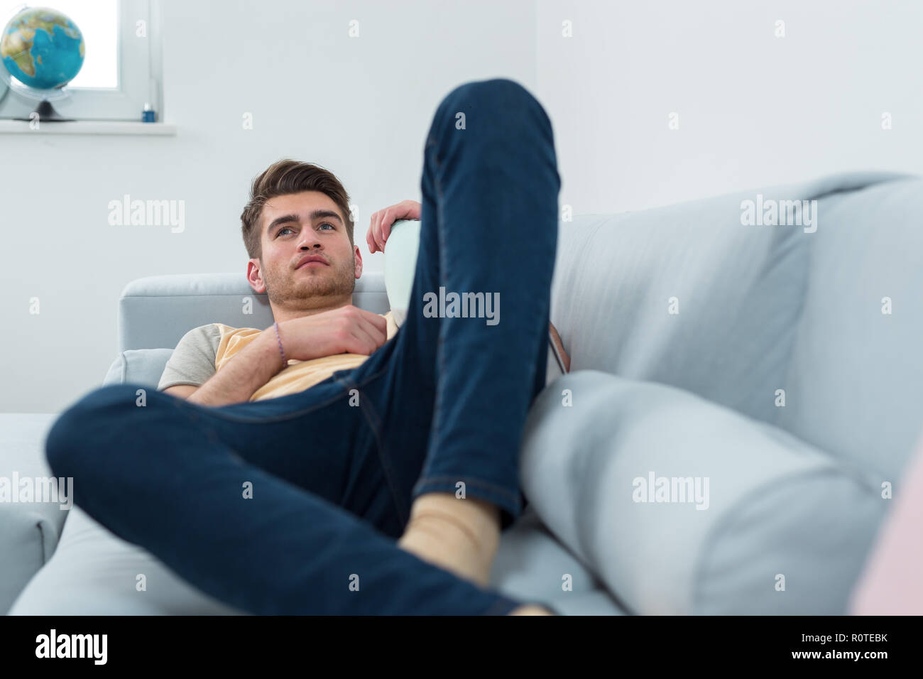 Smiling man resting on couch hi-res stock photography and images - Alamy