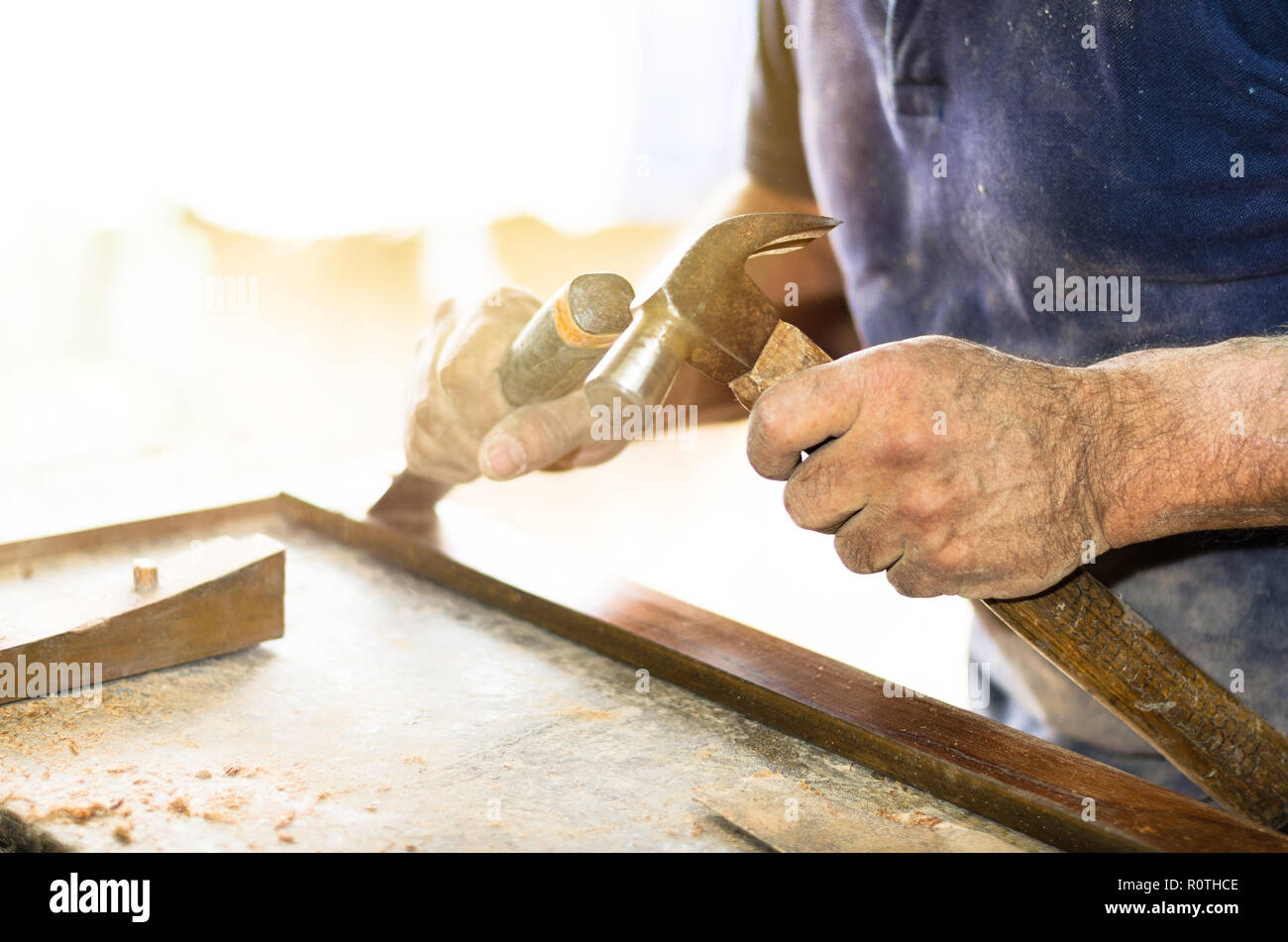 Hands of a carpenter working with a chisel and hammer on wooden ...