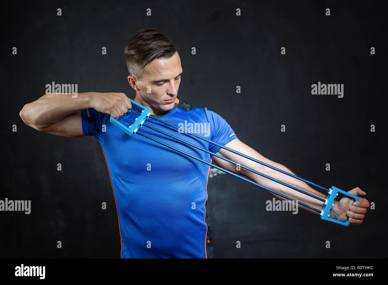 Athletic man doing exercises for hands in a studio Stock Photo - Alamy