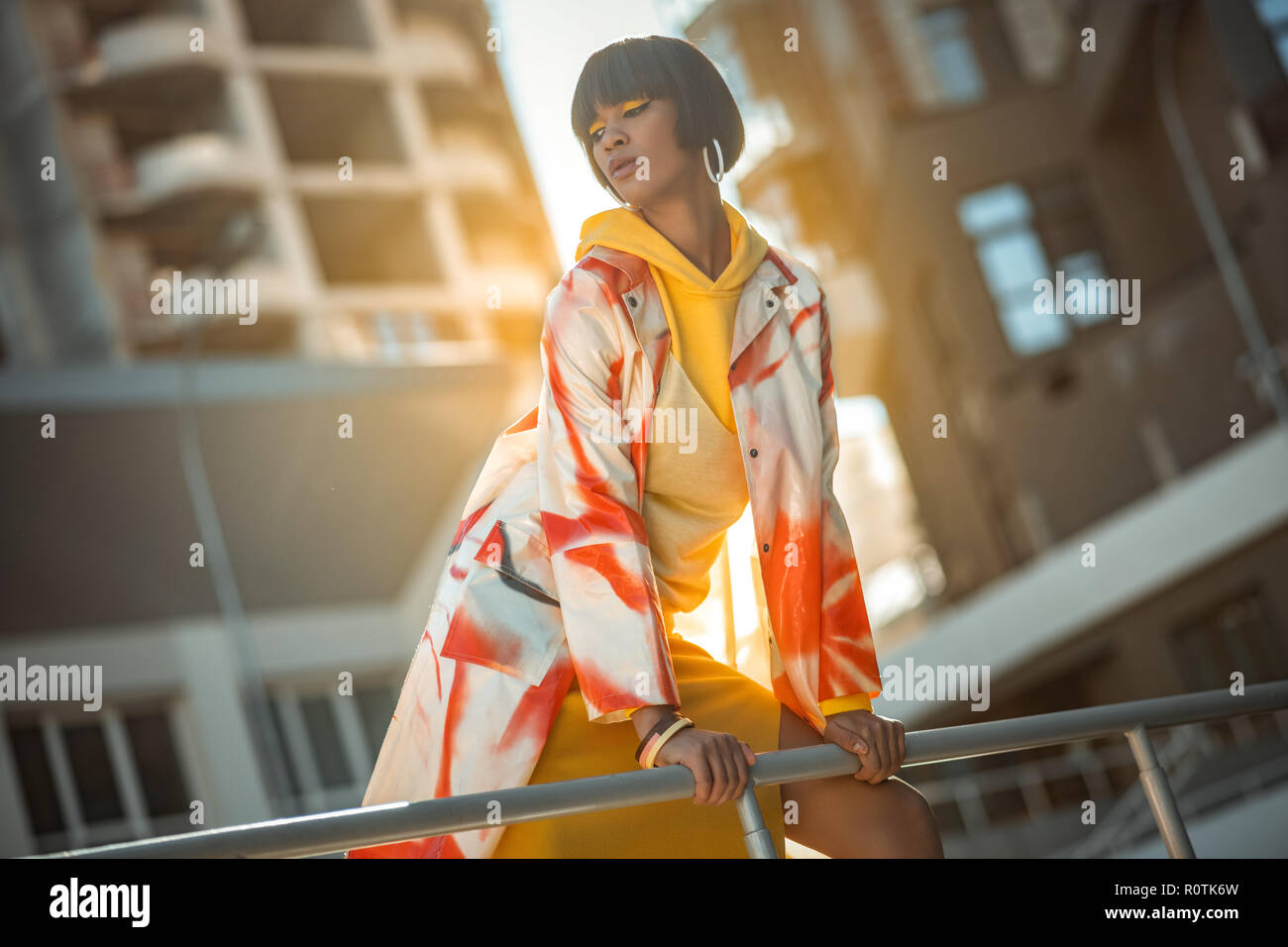 Vicious well-dressed model stooping over handrail exhibiting outfit ...