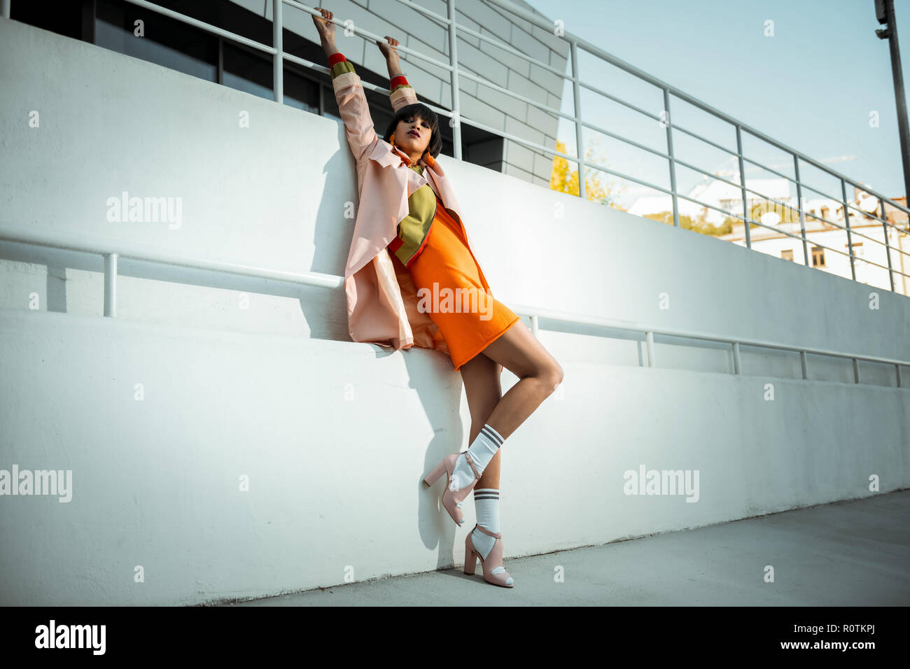 Resolute serious lady holding metal railing with both hands Stock Photo ...