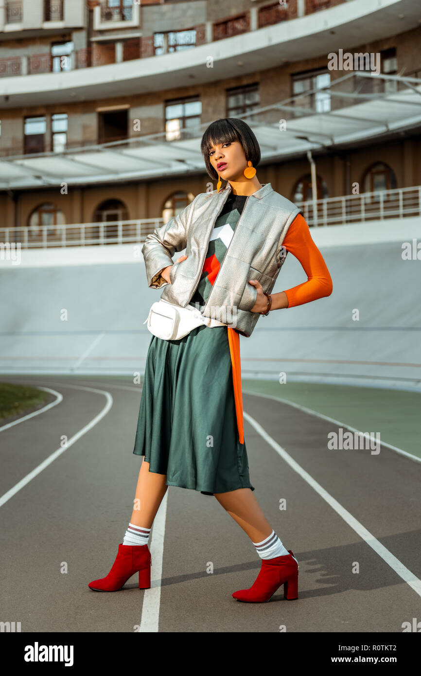 Haughty appealing lady wearing long green skirt and white waist bag ...