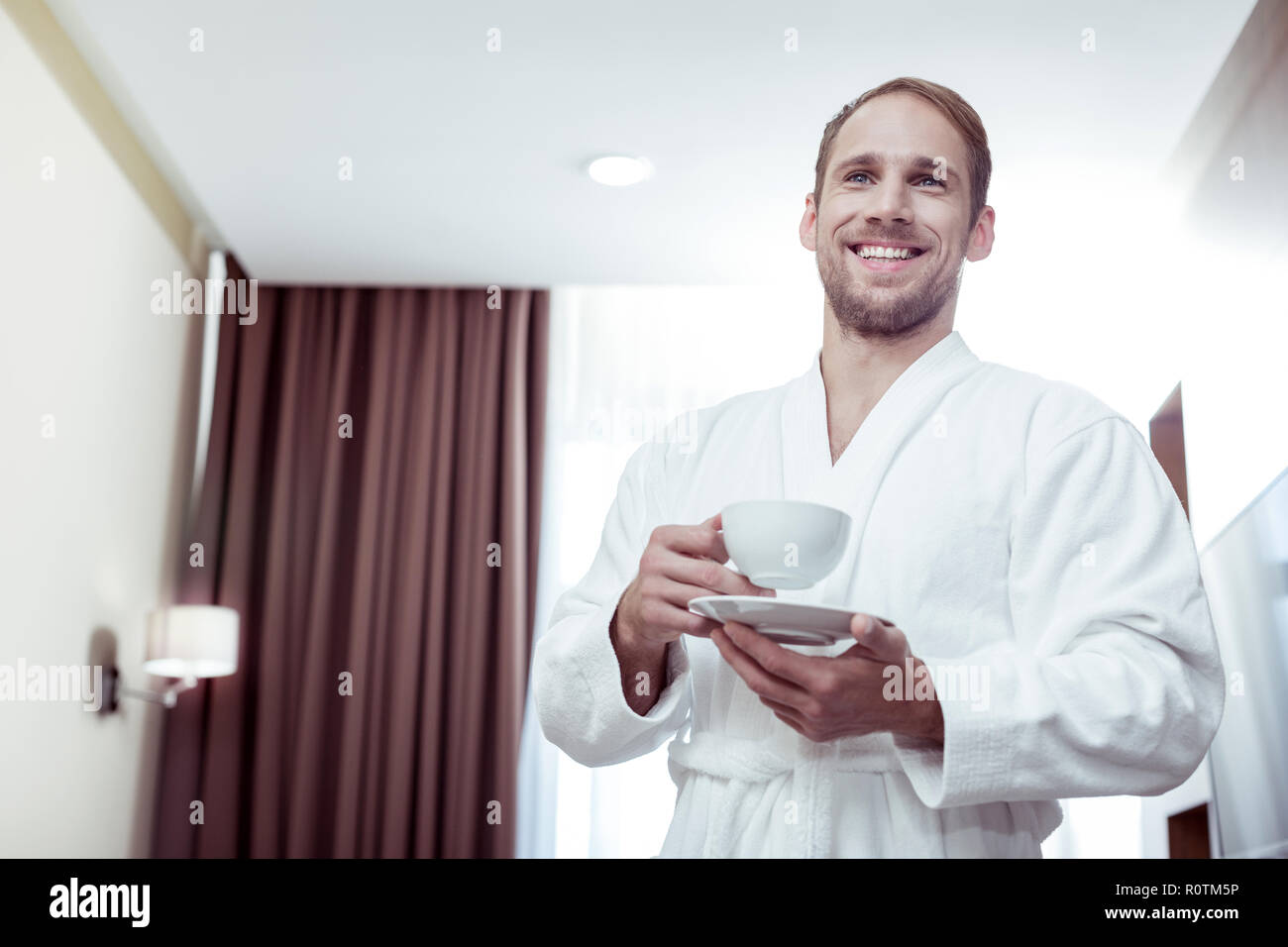 Close up of beaming blonde-haired man drinking his morning coffee Stock ...