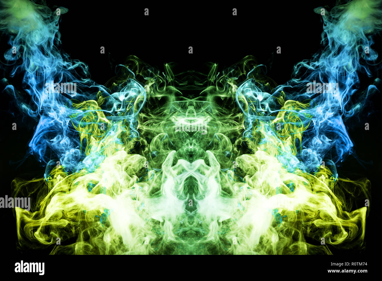 Colorful yellow, green and blue smoke on a black isolated background ...