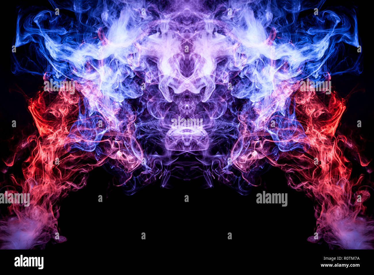 Colorful blue, pink and red smoke on a black isolated background ...