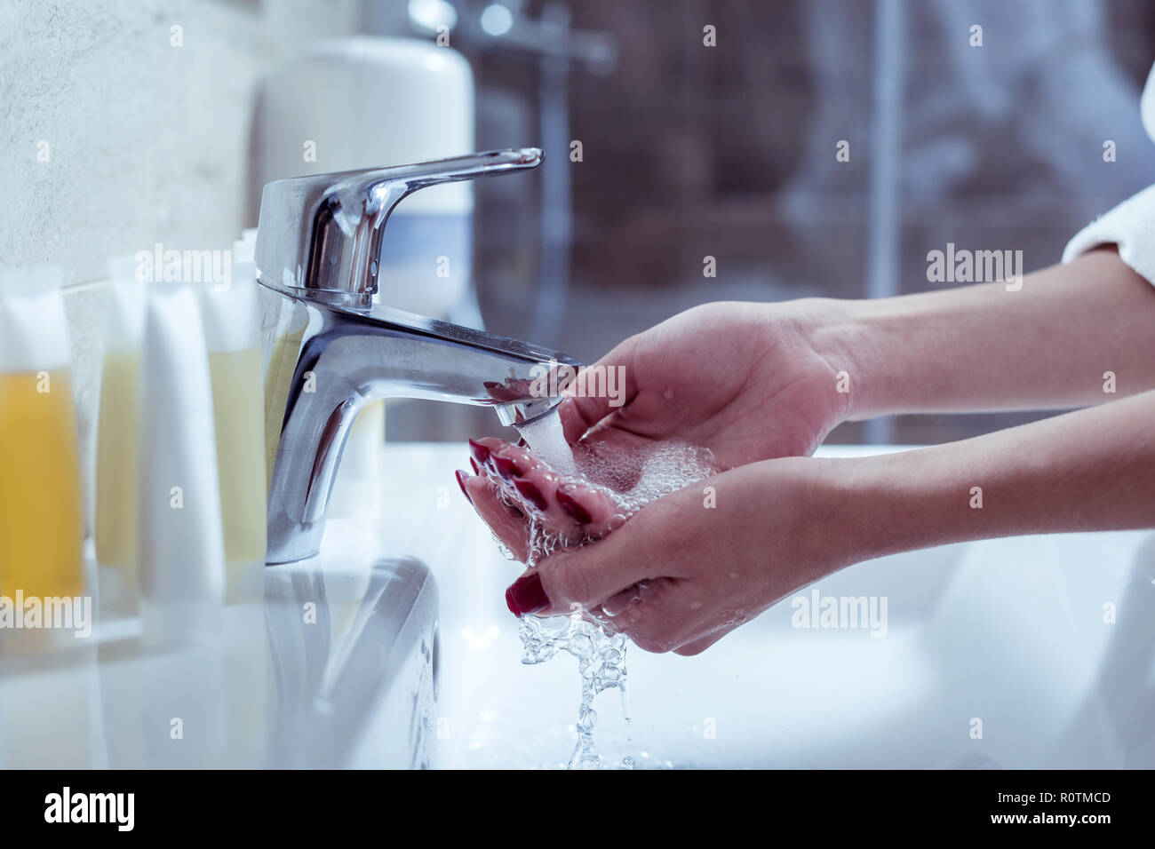 Woman with red nail art washing her hands in the bathroom Stock Photo ...