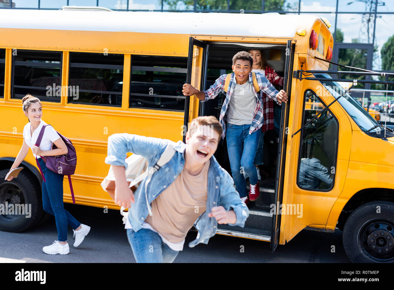 group of teen scholars running out school bus and screaming Stock Photo ...