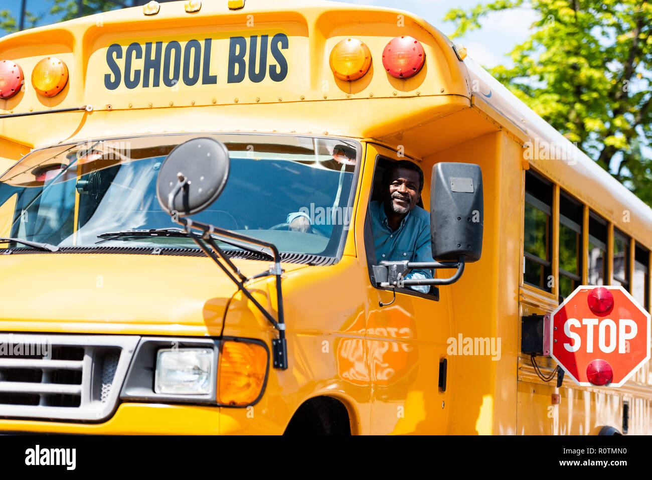 handsome senior school bus driver looking at camera through window ...