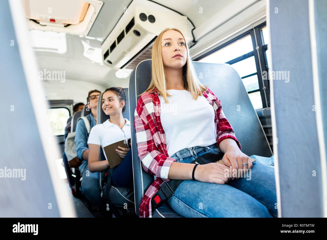 group of teen scholars riding school bus together Stock Photo - Alamy