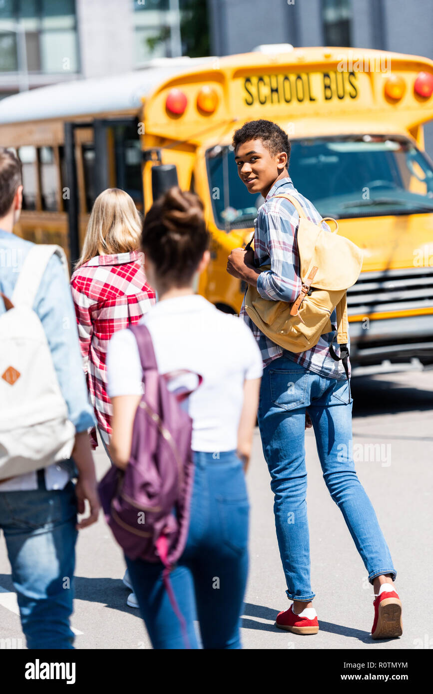 rear view of handsome teen african american schoolboy walking to school ...