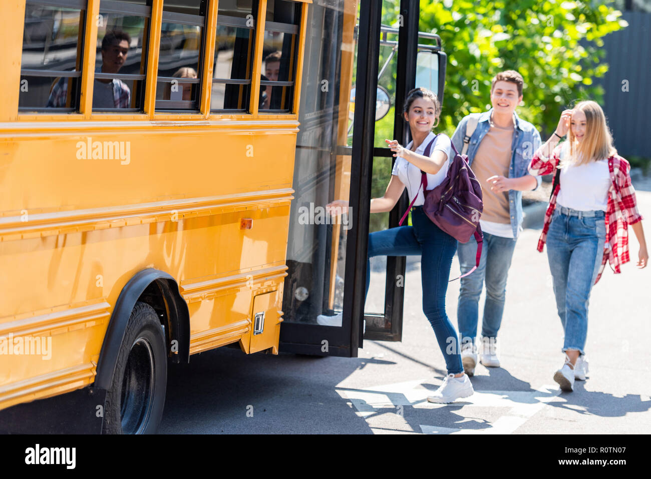 happy teen students walking into school bus Stock Photo - Alamy