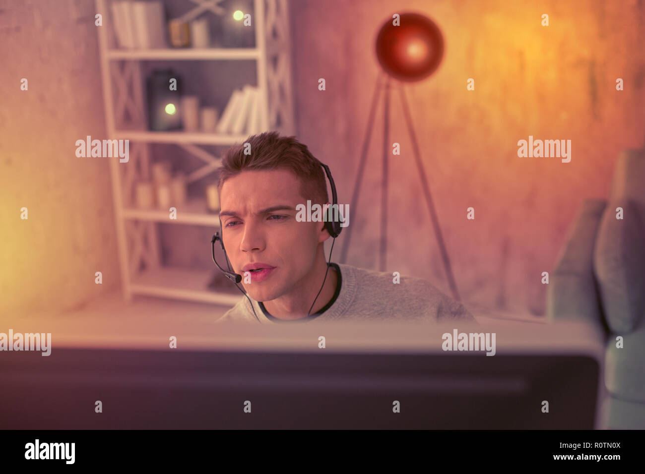 Bemused gamer looking on the screen of computer Stock Photo - Alamy