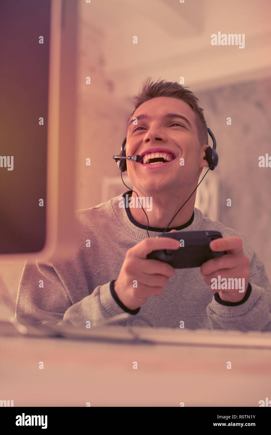 Short haired gamer openly smiling while playing Stock Photo - Alamy