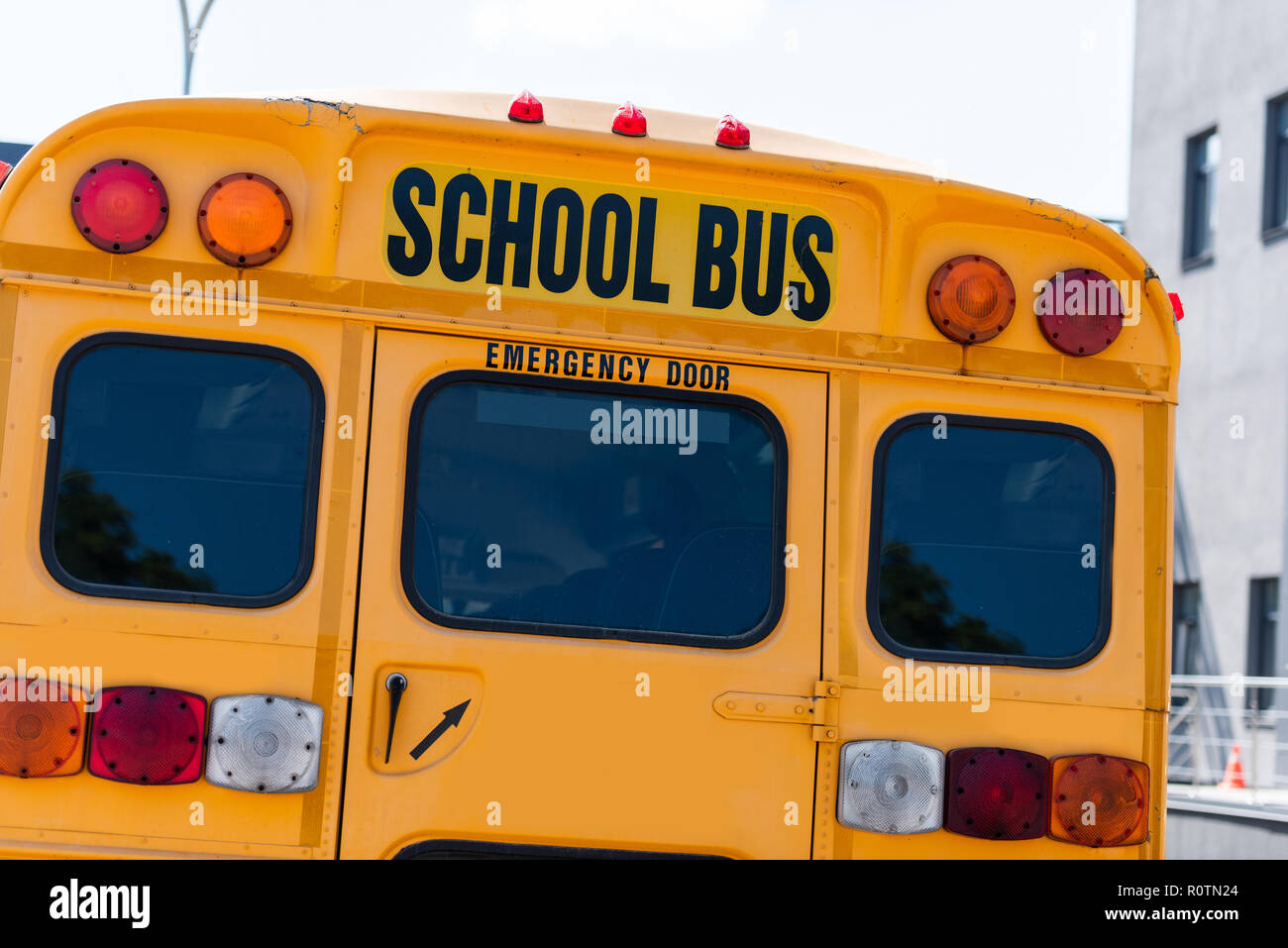 rear view of traditional school bus with inscription over back door ...