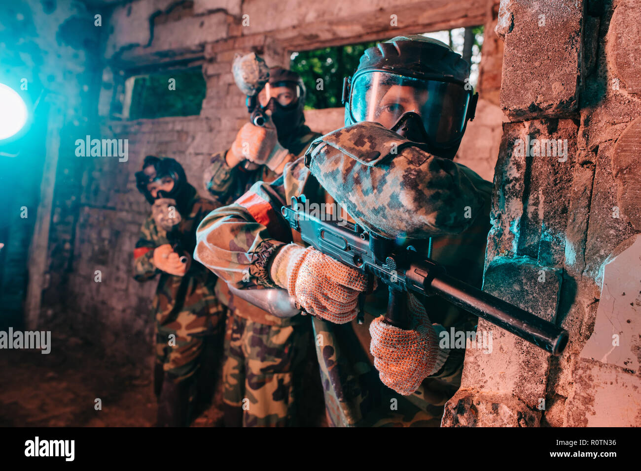 selective focus of paintball team in uniform and protective masks ...