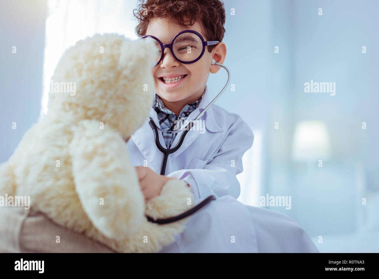Joyful positive boy looking at his toy Stock Photo - Alamy