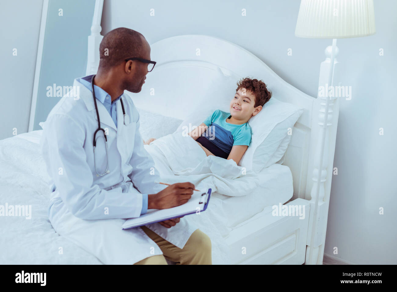 Cute ill boy answering different doctors questions Stock Photo - Alamy
