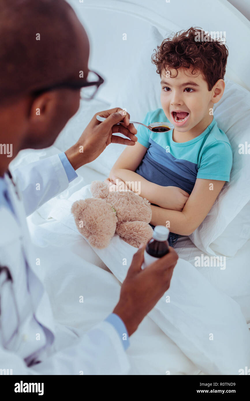 Positive sick boy being ready to take medicine Stock Photo - Alamy
