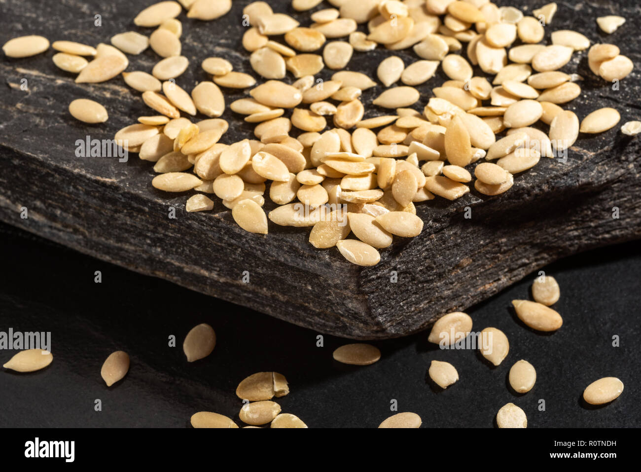 Pile of shelled melon seeds on a slab of black rock Stock Photo - Alamy