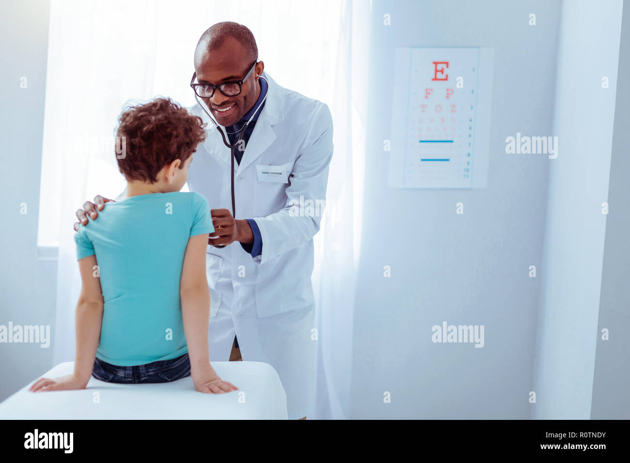 Positive skilled doctor leaning to his patient Stock Photo - Alamy