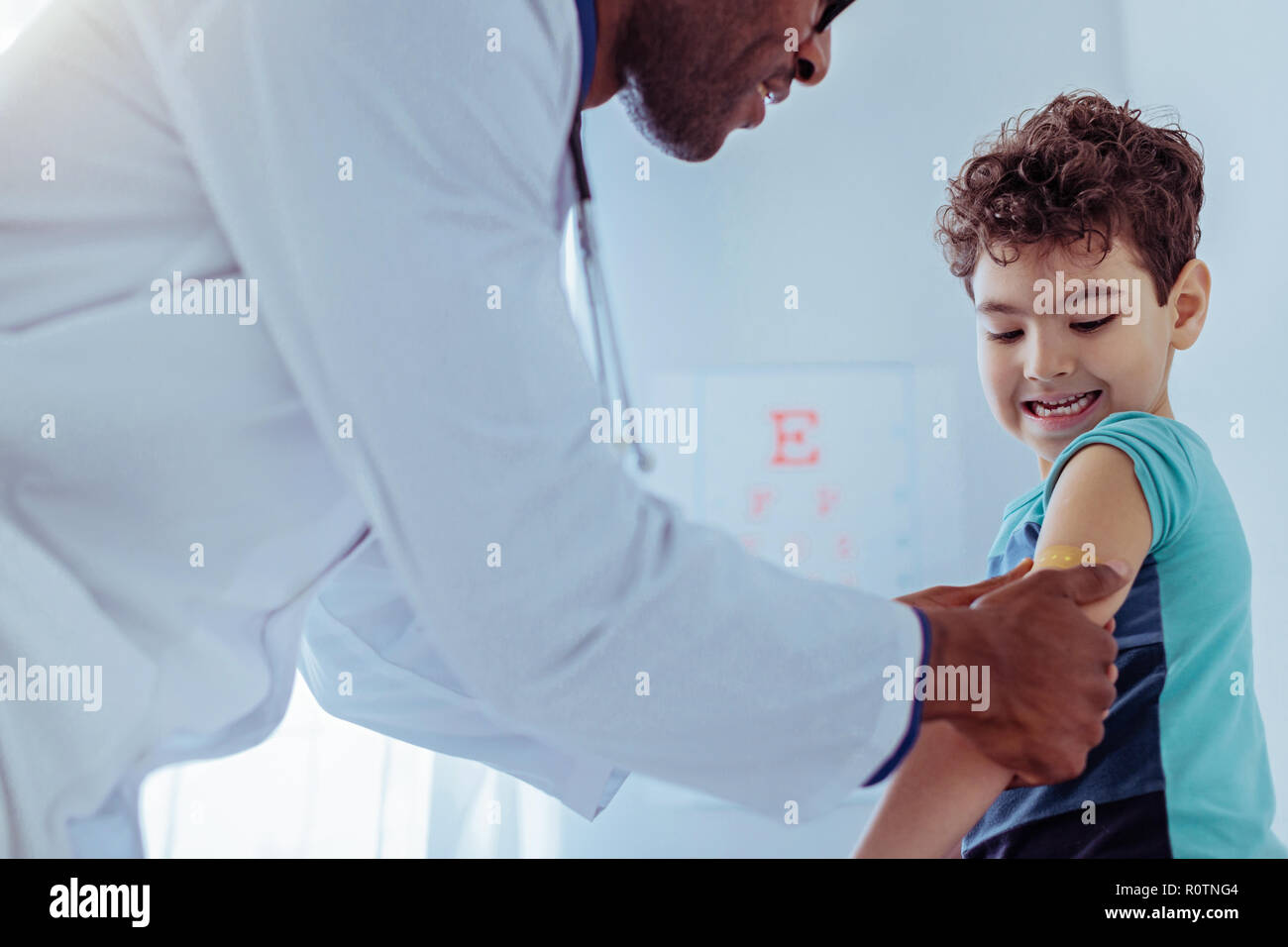 Cute nice boy looking at his arm Stock Photo - Alamy