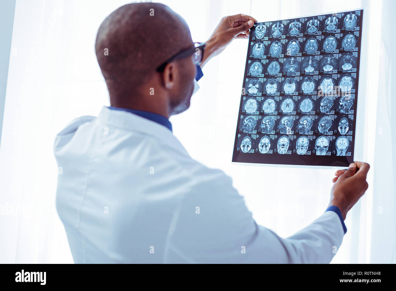 Smart nice doctor checking an X-ray image Stock Photo - Alamy