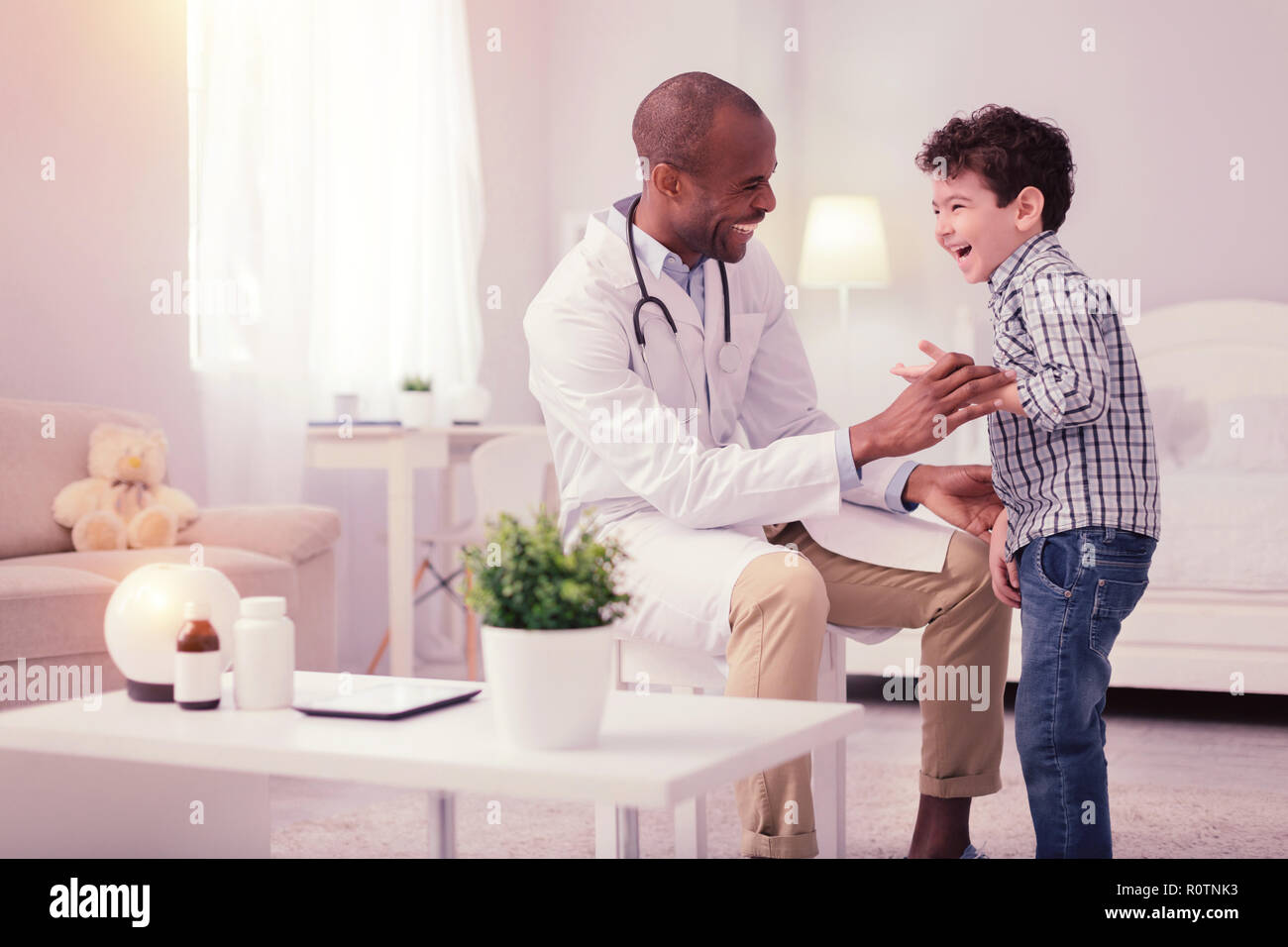 Happy positive boy standing near his doctor Stock Photo - Alamy