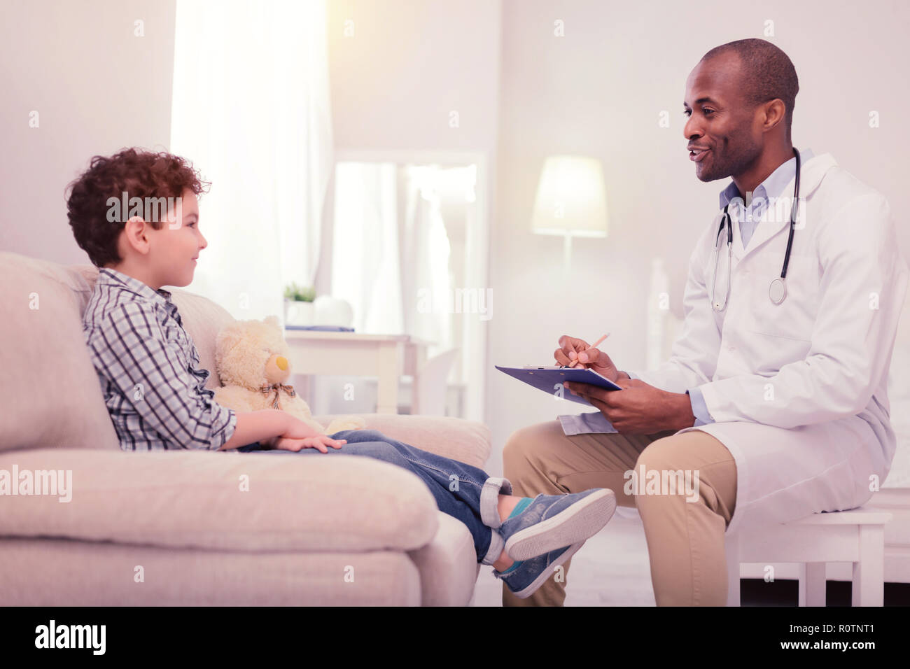 Positive friendly doctor speaking with his patient Stock Photo - Alamy