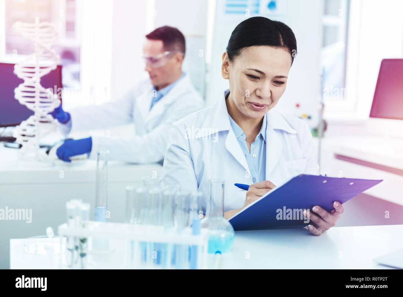 Nice smart woman taking notes while working Stock Photo - Alamy
