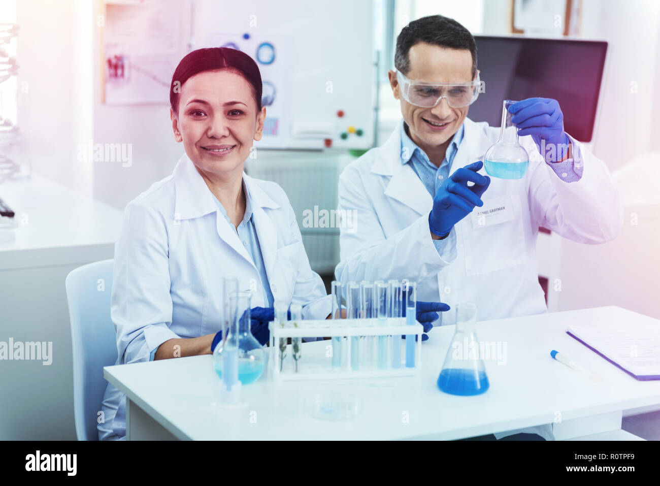 Joyful intelligent scientists sitting together at the table Stock Photo ...
