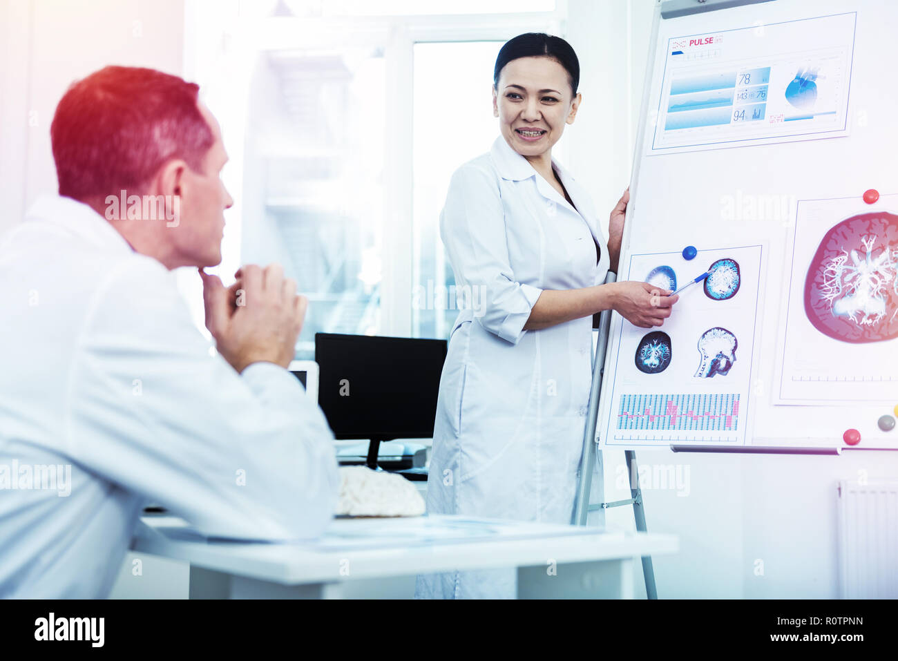 Positive smart woman pointing at the brain image Stock Photo - Alamy