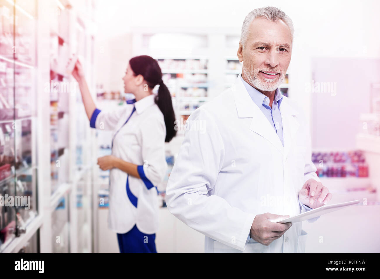 Professional chemists actively working in a modern pharmacy Stock Photo ...