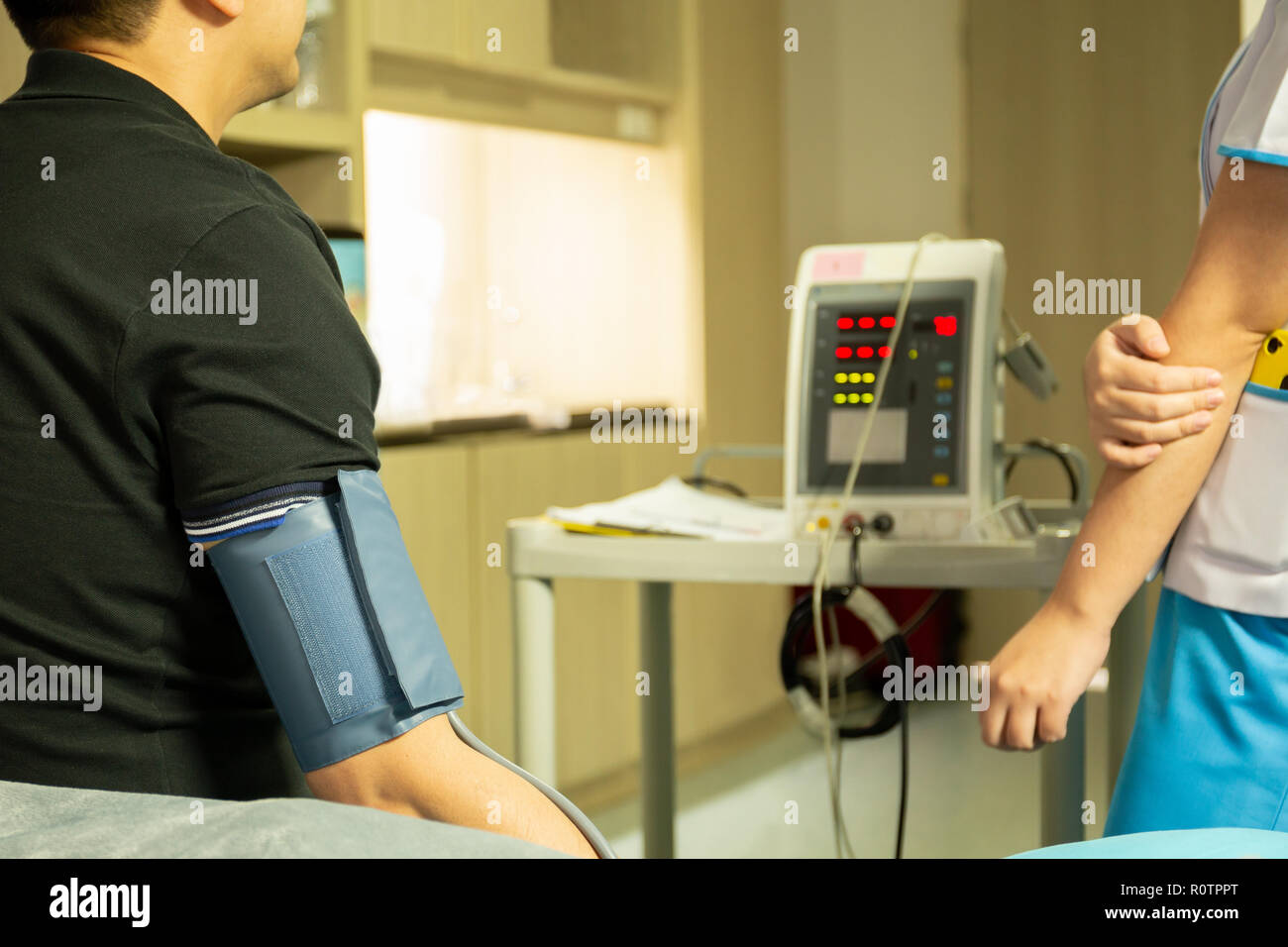 Nurse checking blood pressure on monitor screen for patient health in ...