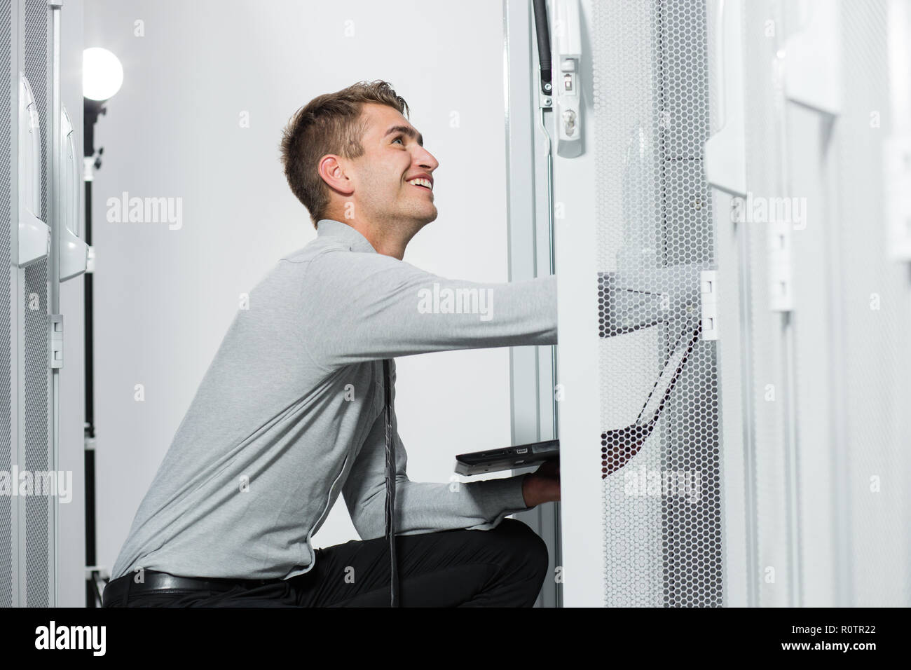 Male Server Engineer Works on a Laptop in Large Data Center Stock Photo ...