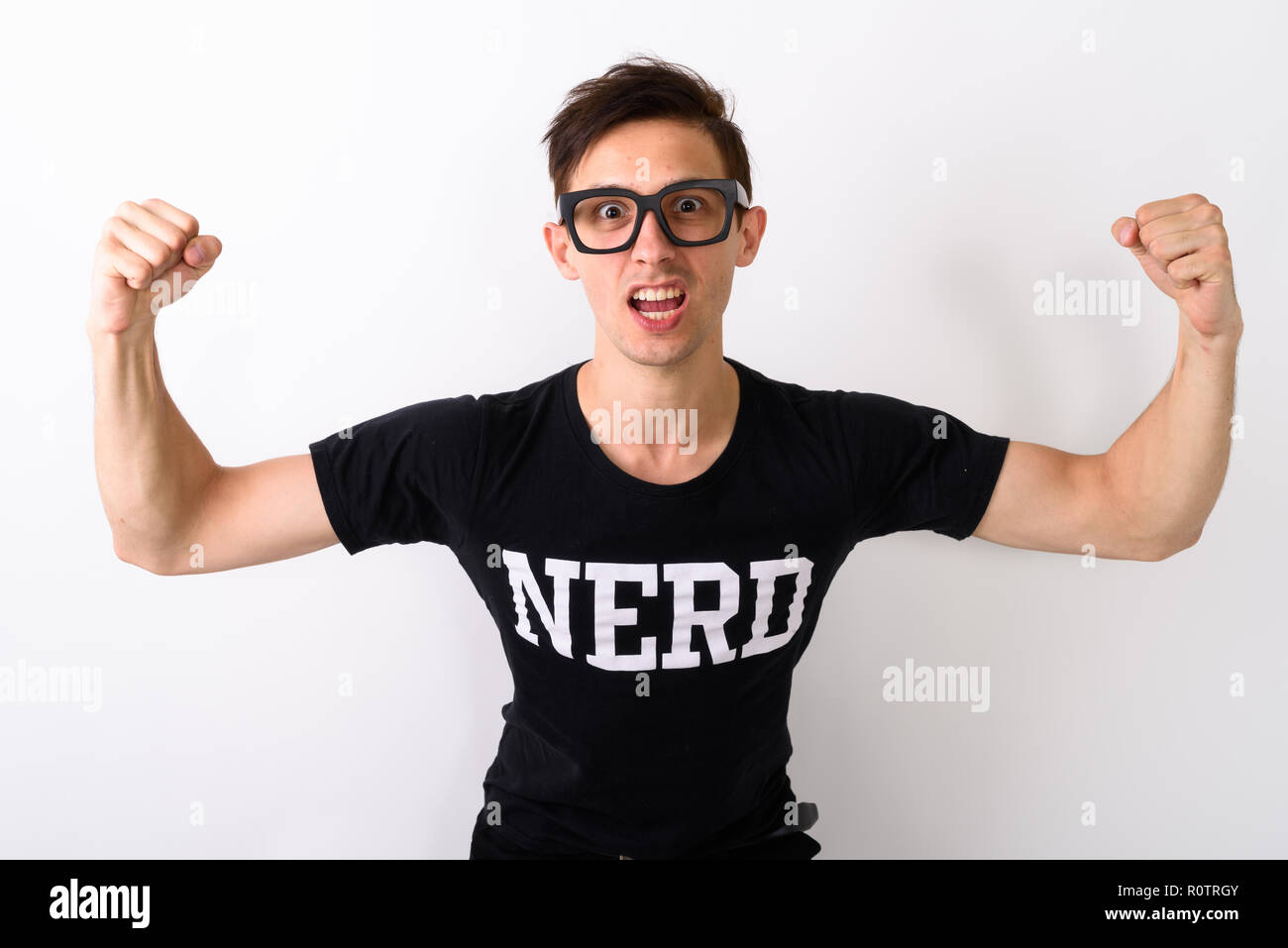 Studio shot of young nerd man flexing both arms while wearing ey Stock ...