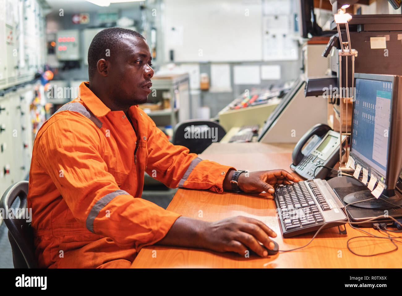 Marine engineer officer working in engine room Stock Photo - Alamy