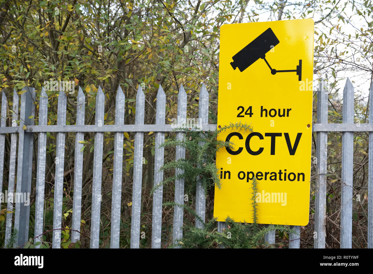 CCTV yellow sign on security railing Stock Photo - Alamy