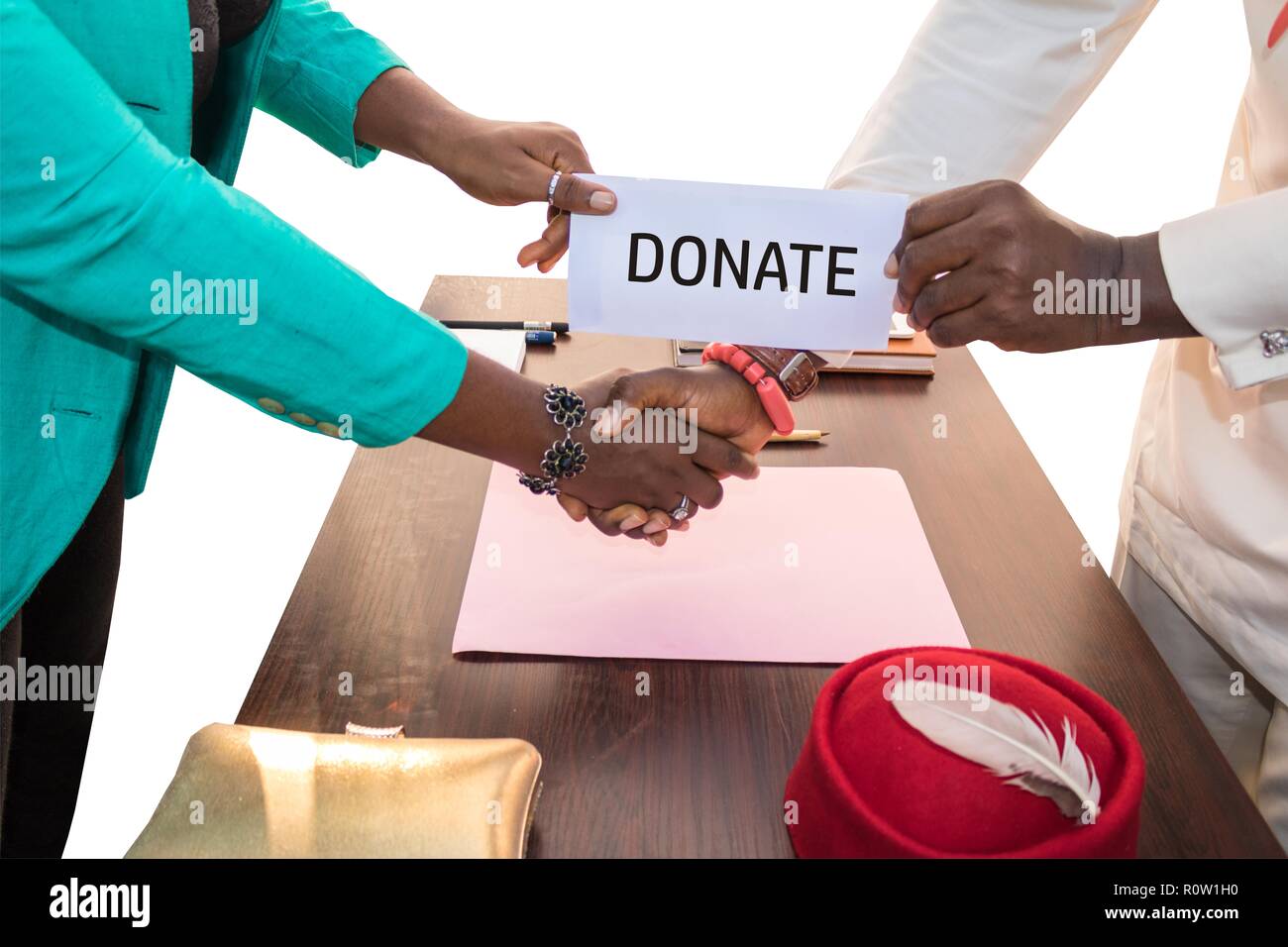 An African business man and woman exchange handshake and envelope ...