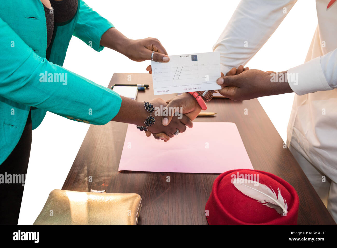 Am African business man and woman shake hands as they give and receive ...
