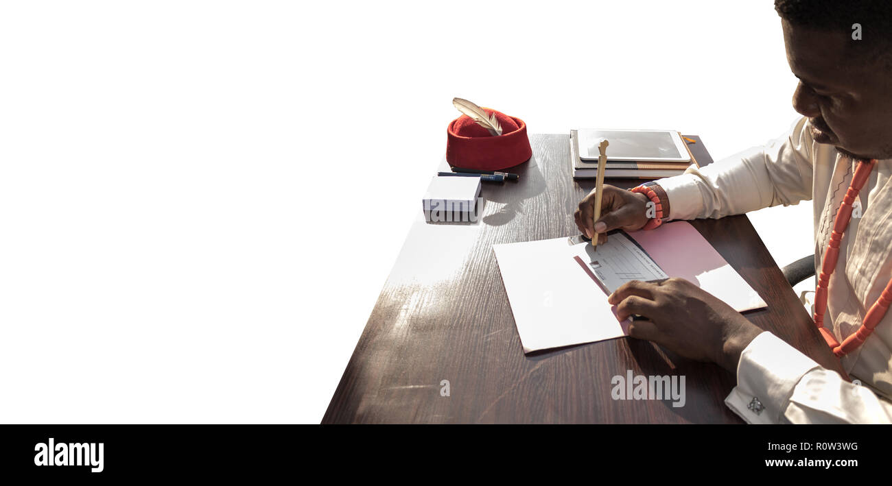 An African business man signs a cheque at his office table and writing ...