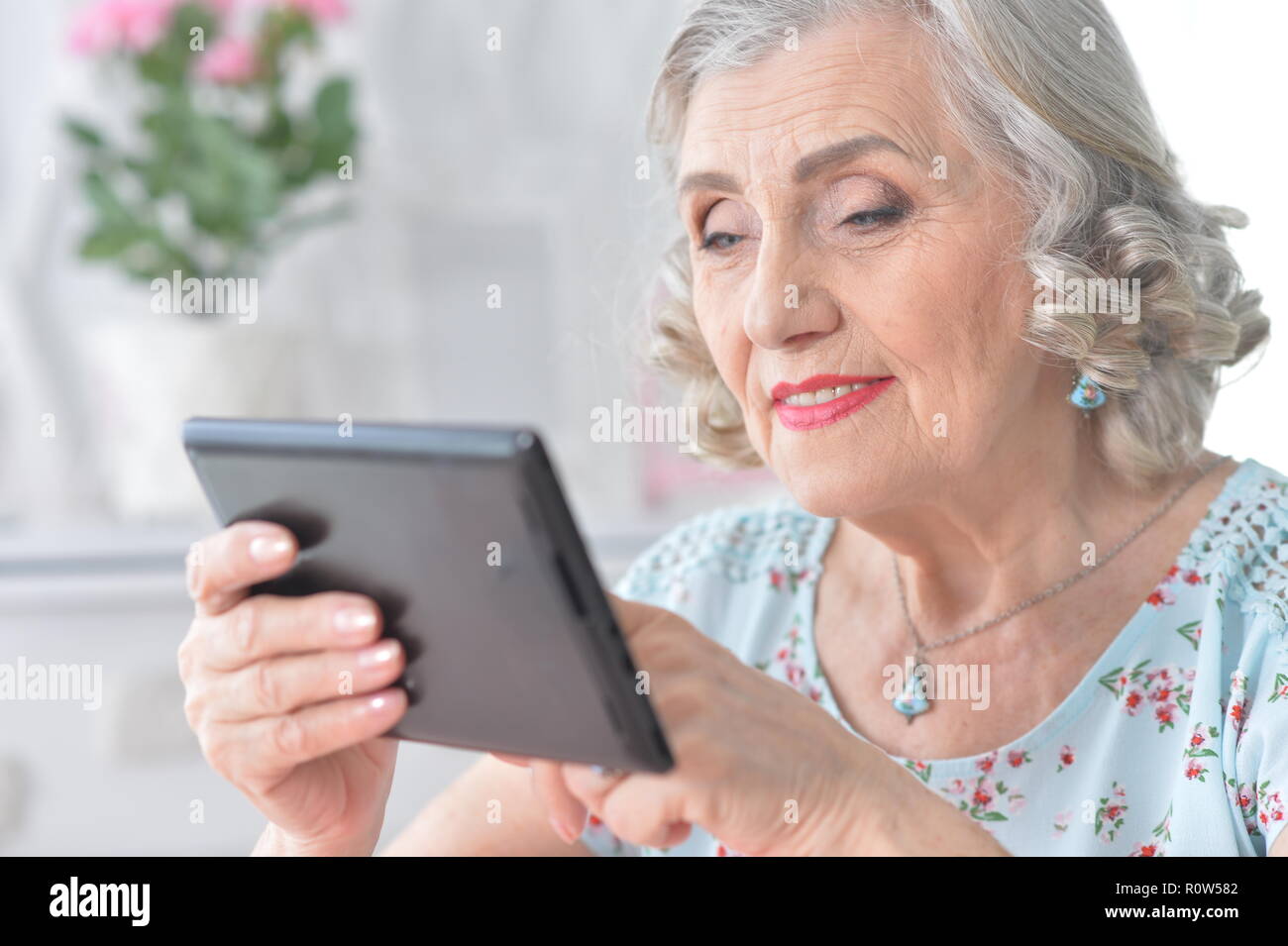 Portrait of cute old woman with tablet Stock Photo - Alamy