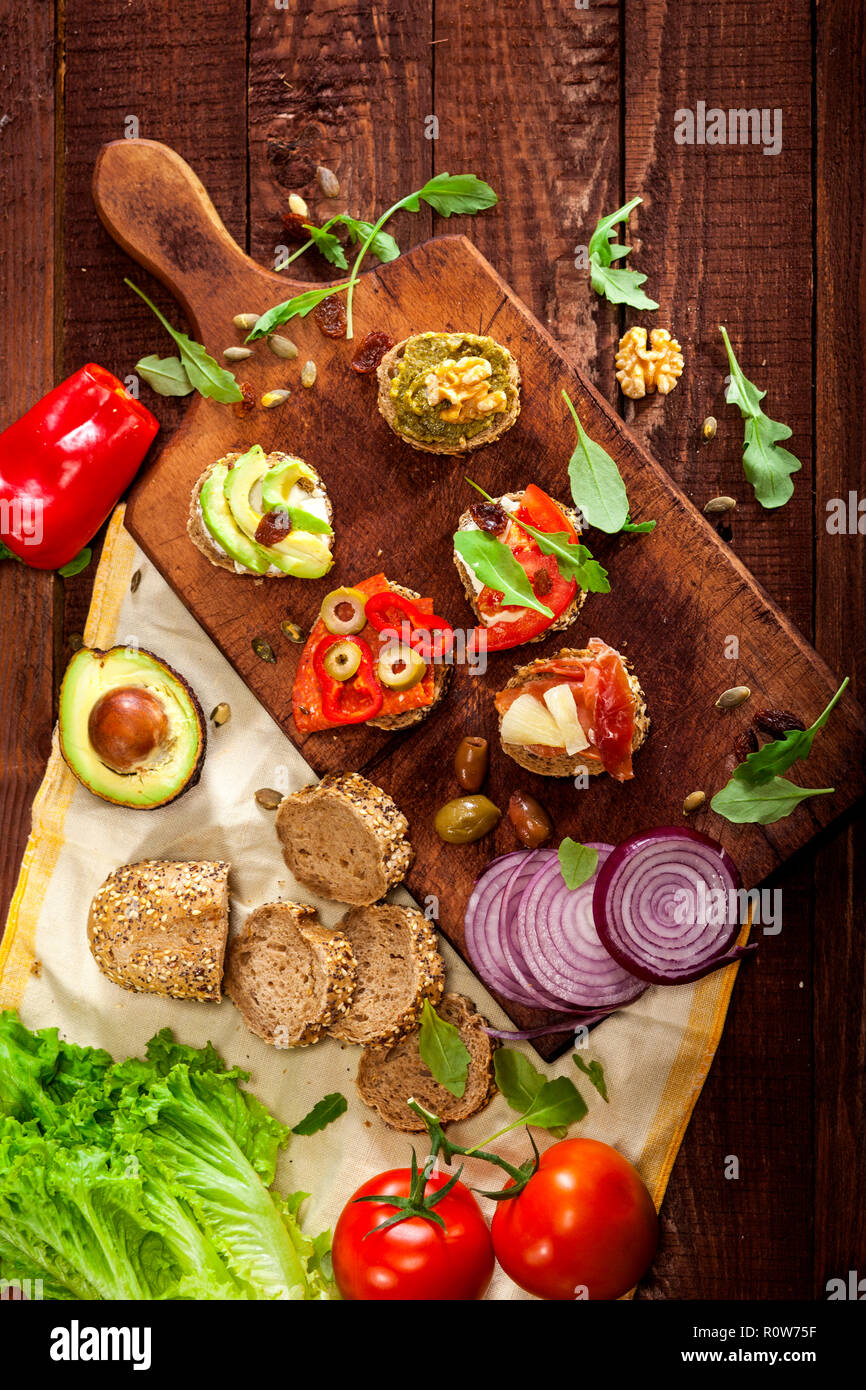 Collection of different mini sandwiches on a cutting board and wooden ...