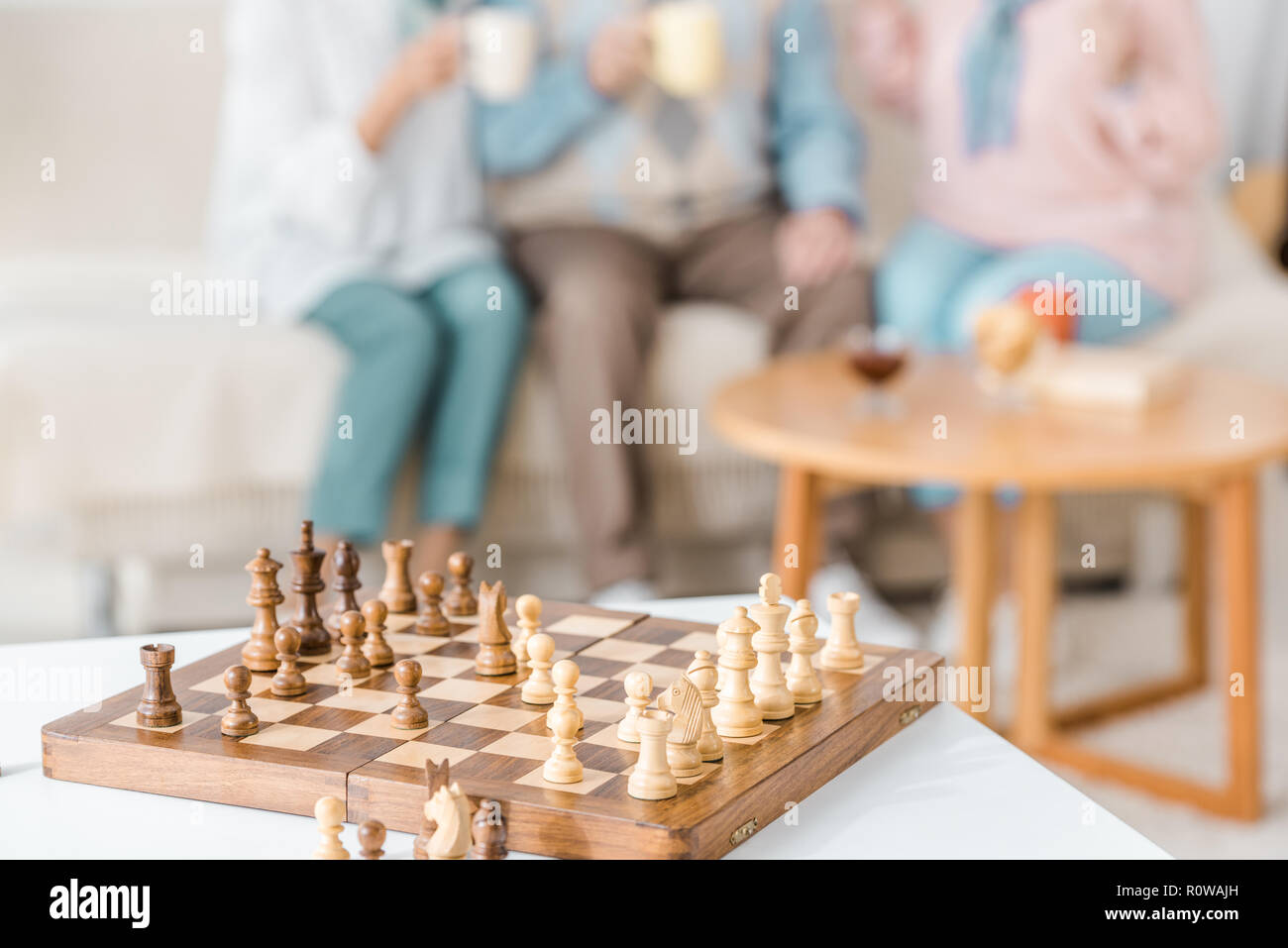 wooden chess desk with figures and blurred people at background Stock ...