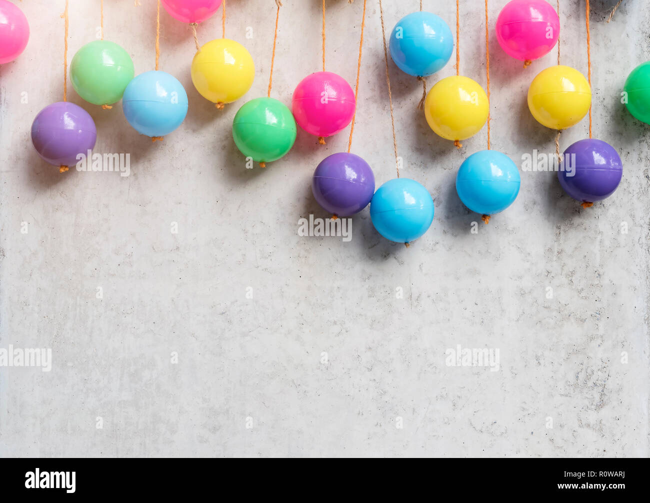 Abstract background from colorful balls hang on grey concrete wall ...