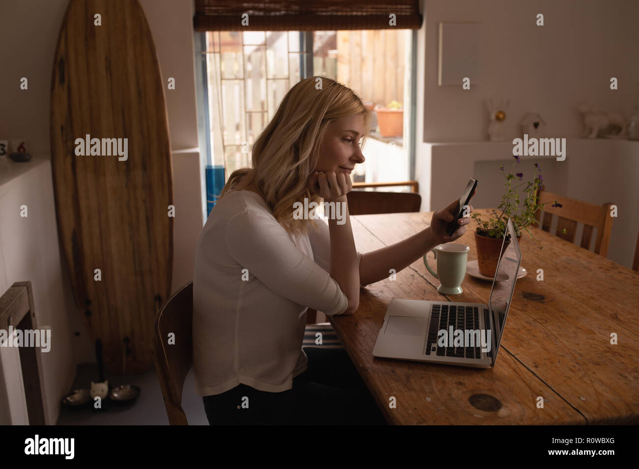 Woman using mobile phone at home Stock Photo - Alamy