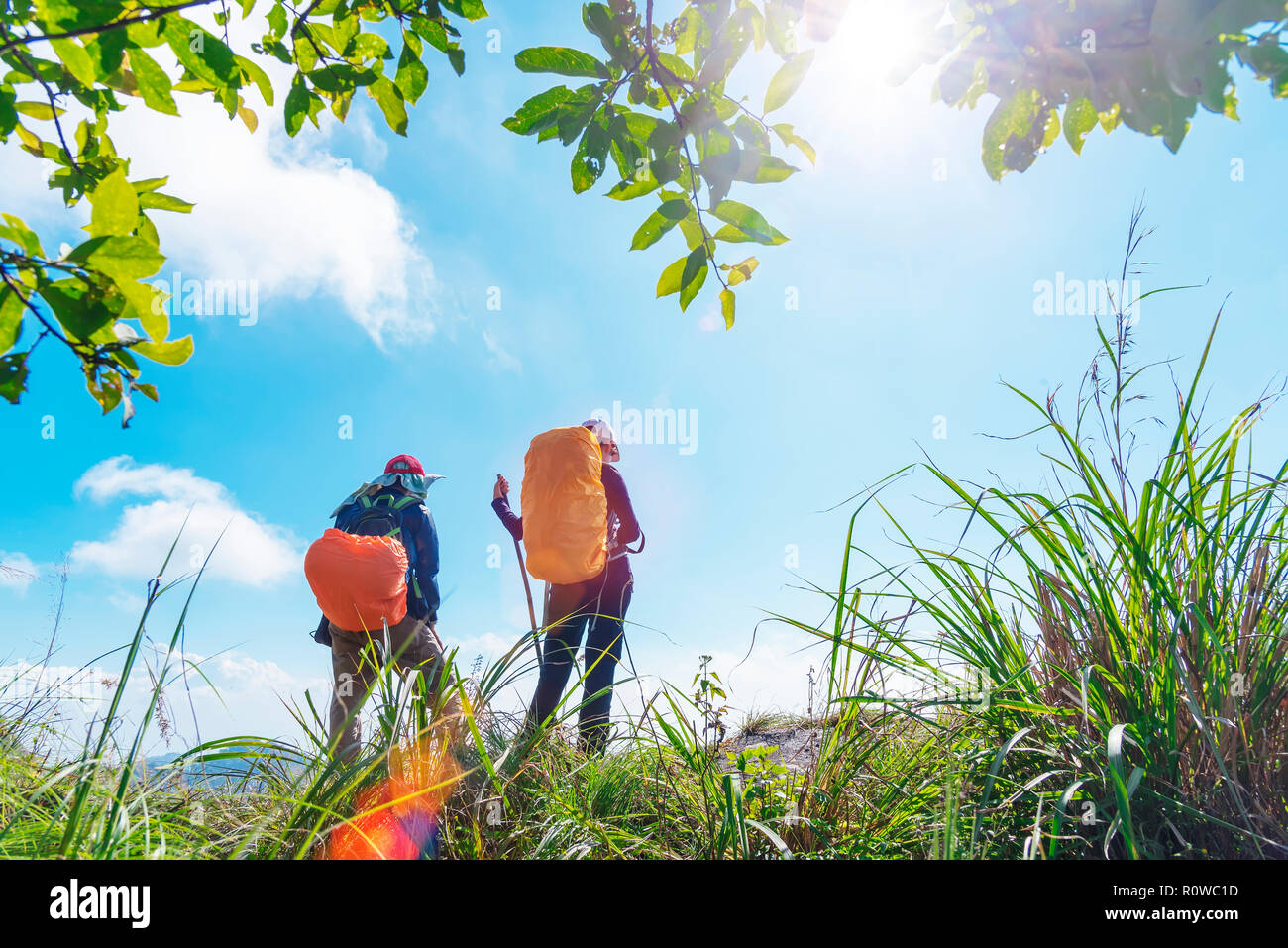 Travel background. Two backpacker standing on top of mountain looking ...