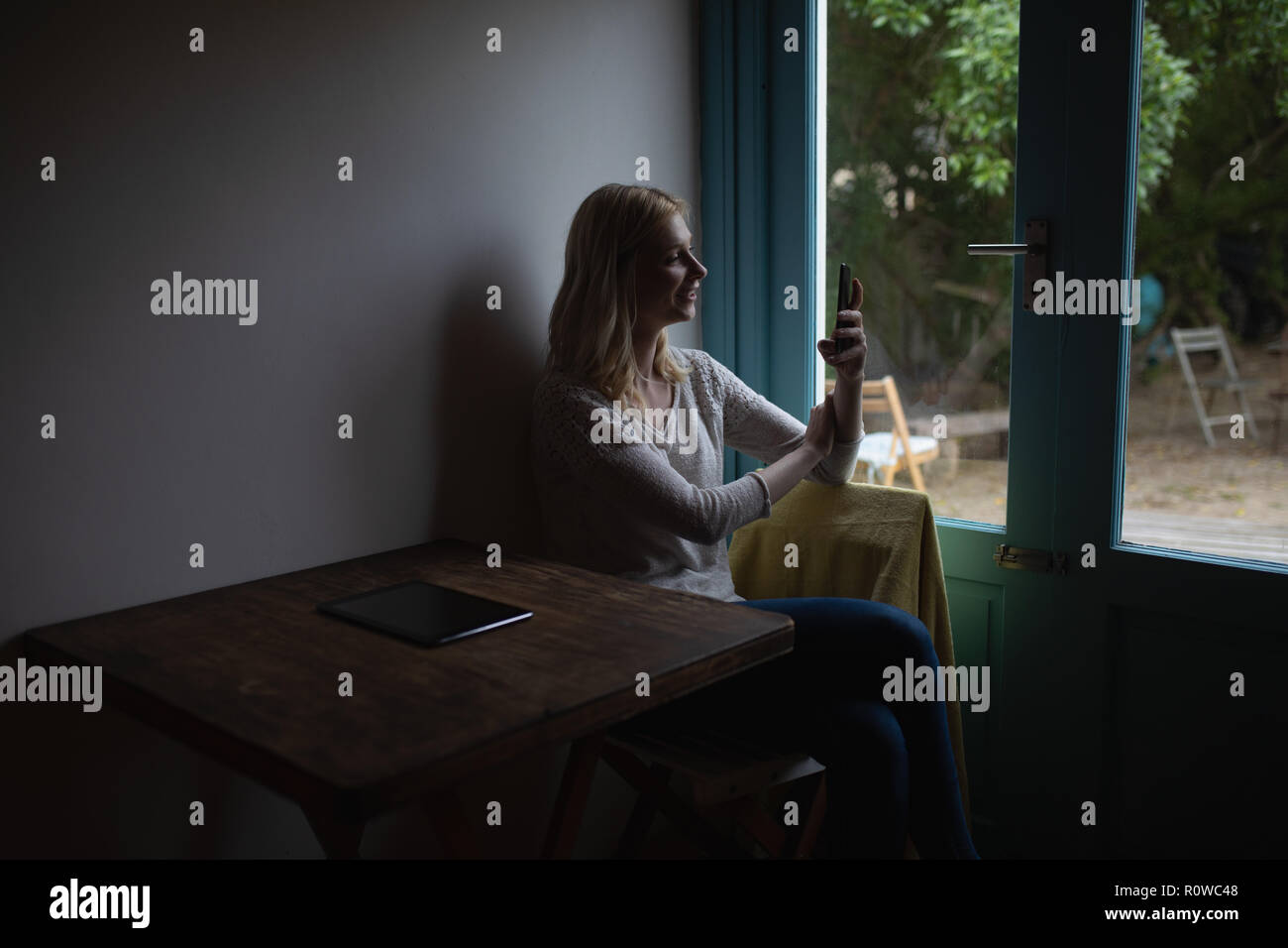 Woman using mobile phone at home Stock Photo - Alamy