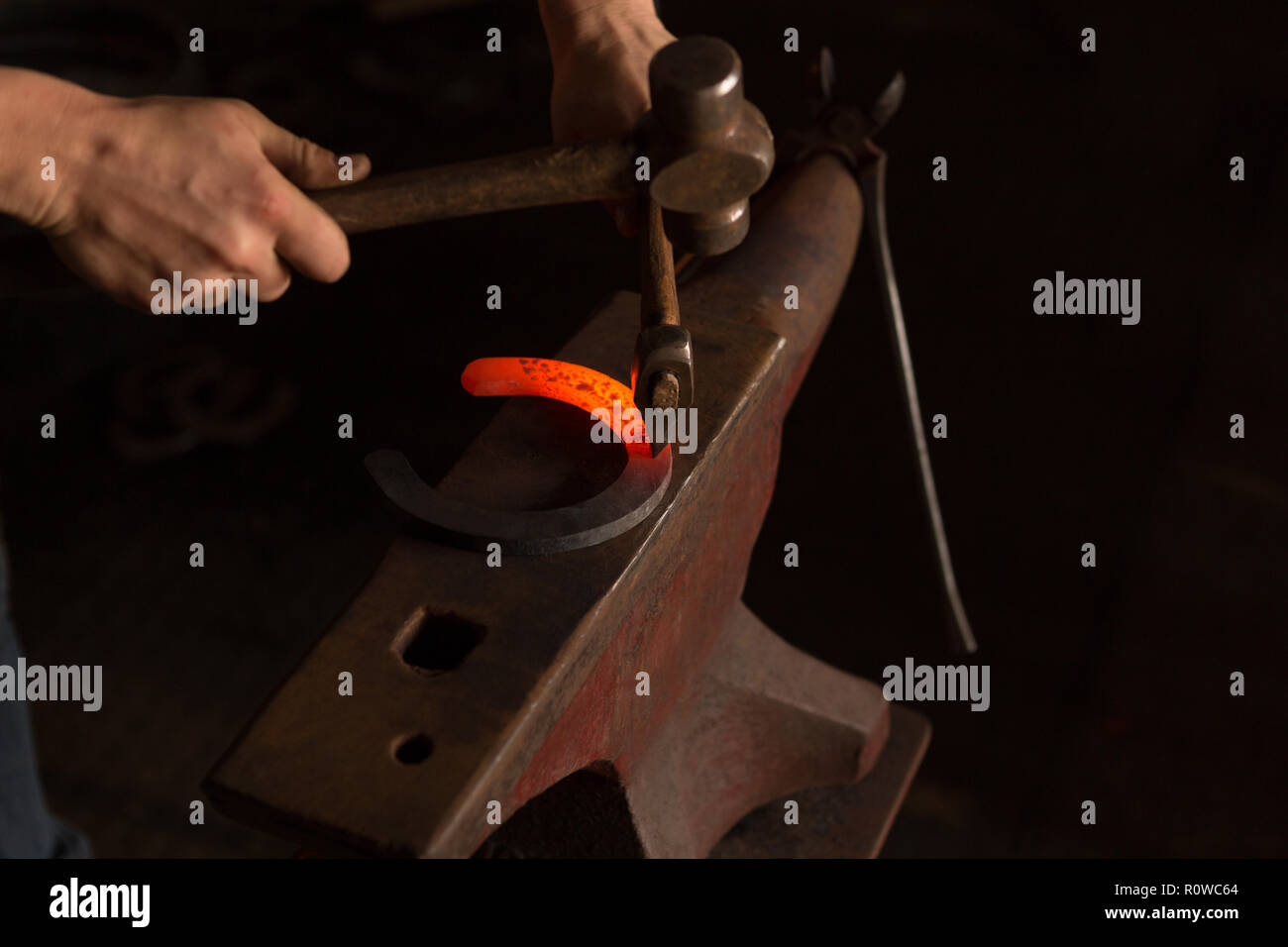 Female metalsmith molding horseshoe in factory Stock Photo - Alamy
